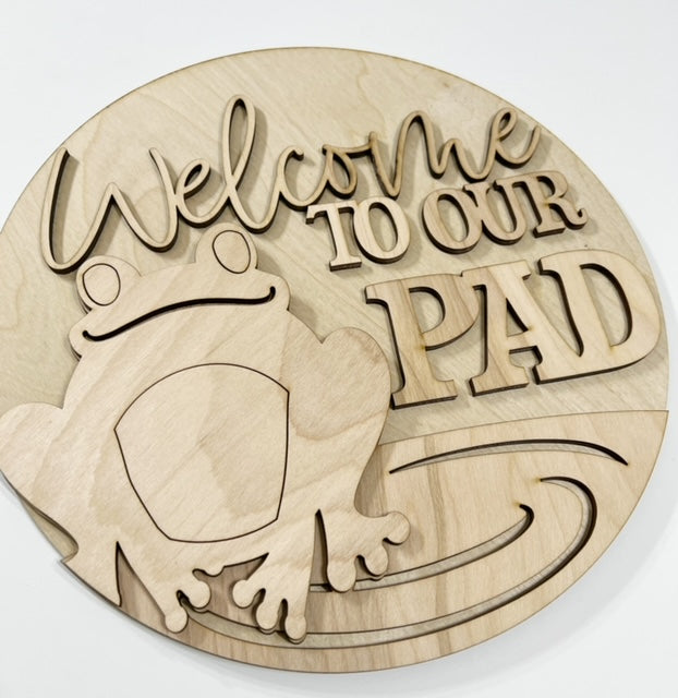Cute Frog Welcome To Our Pad Round Doorhanger – Sawdust & Swirls